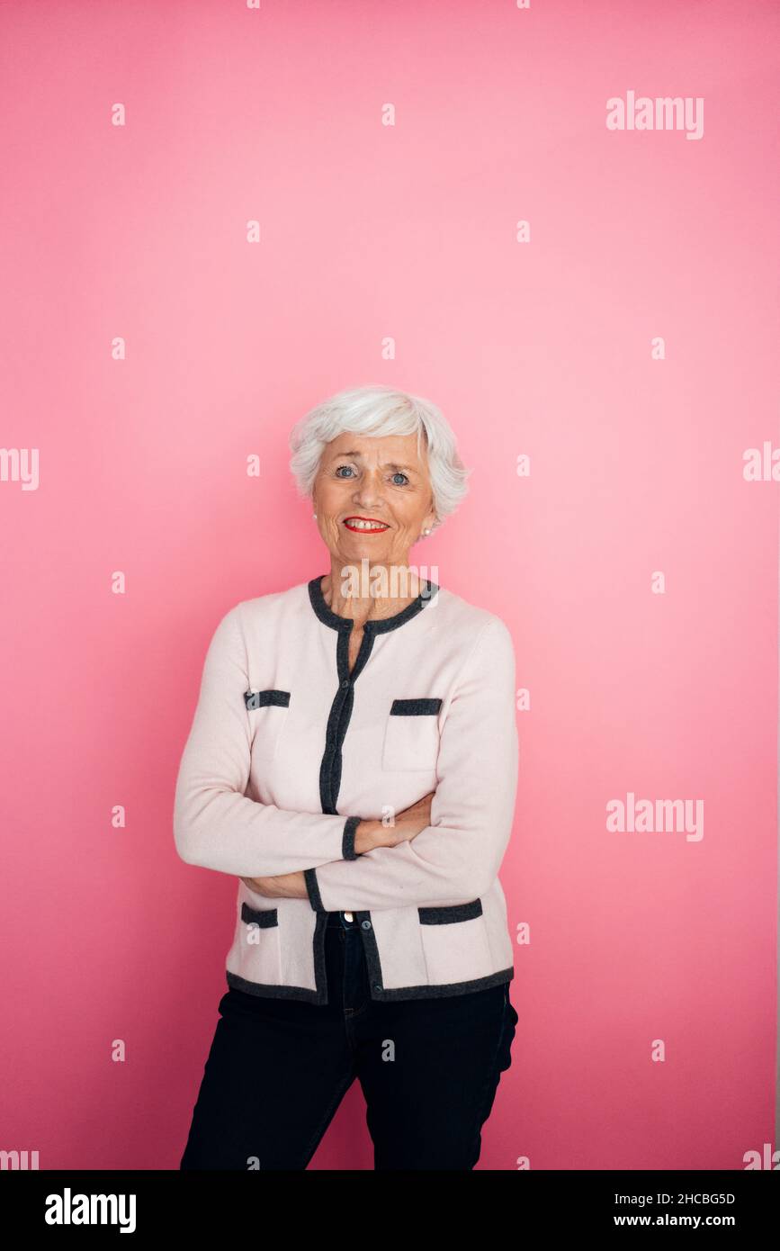 Senior woman smiling against pink background Stock Photo - Alamy