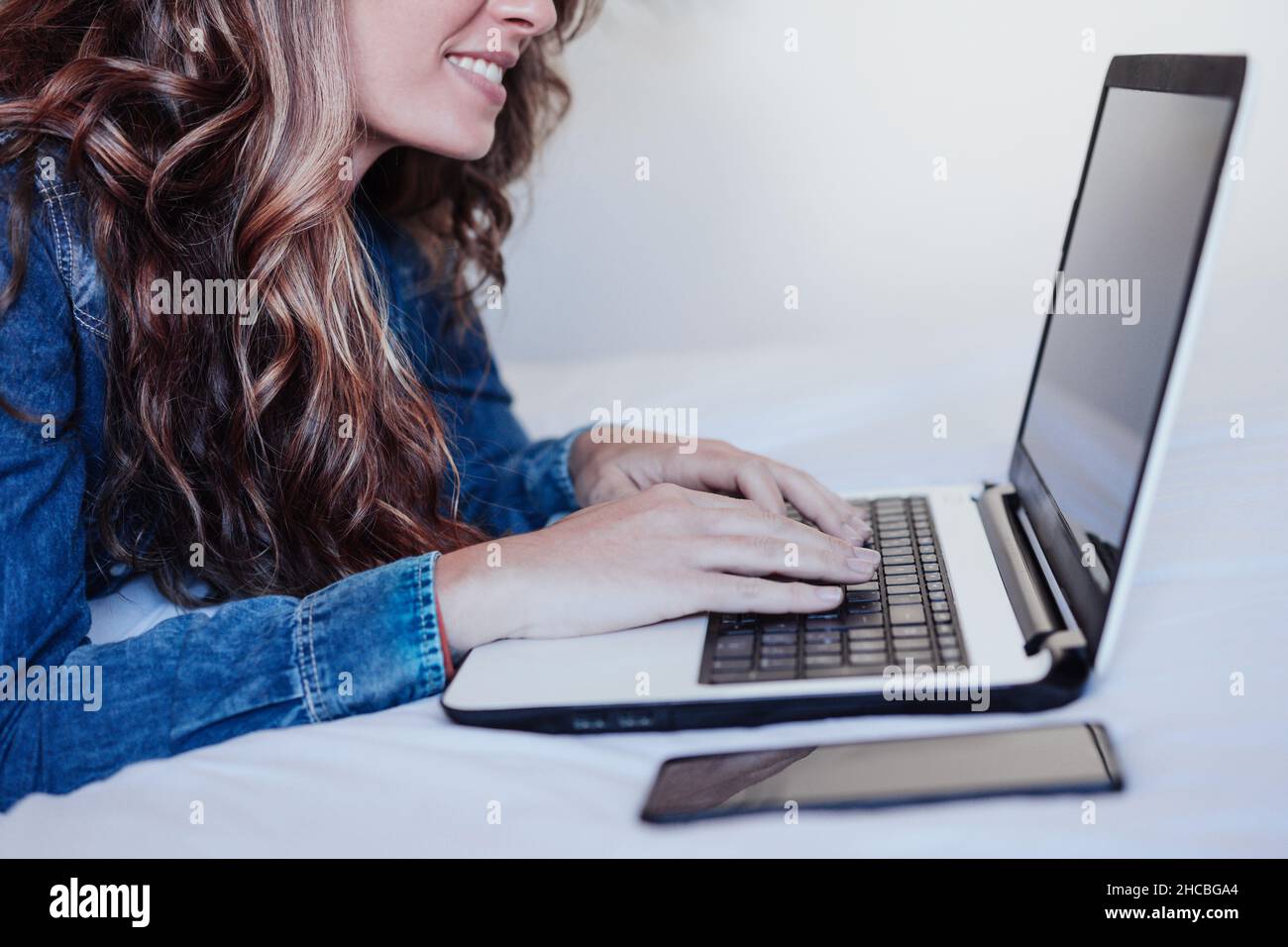 Woman using laptop in bedroom hi-res stock photography and images - Alamy