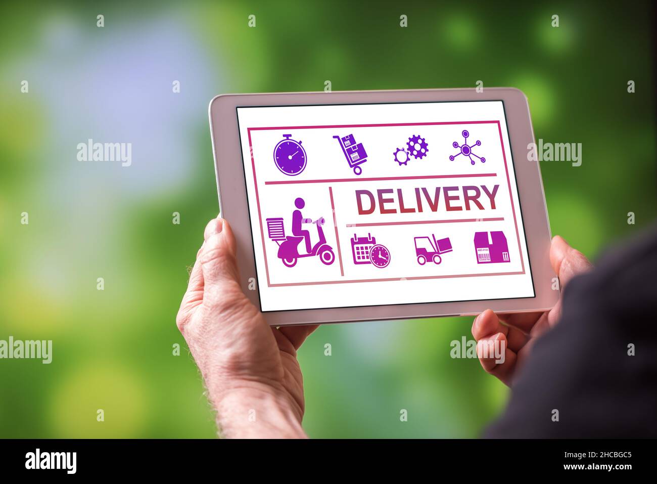 Man holding a tablet showing delivery concept Stock Photo - Alamy