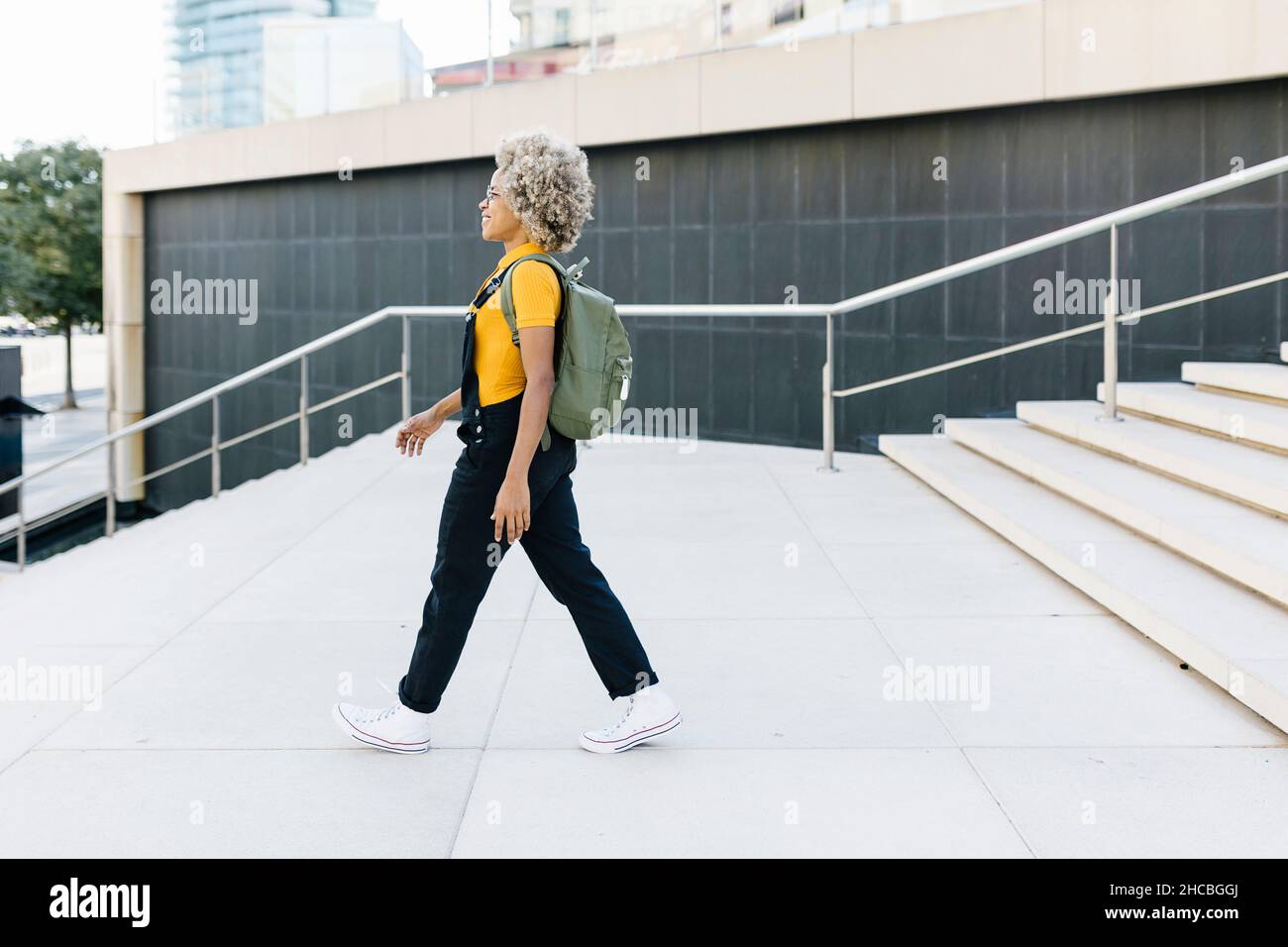 Woman with backpack walking on staircase Stock Photo - Alamy
