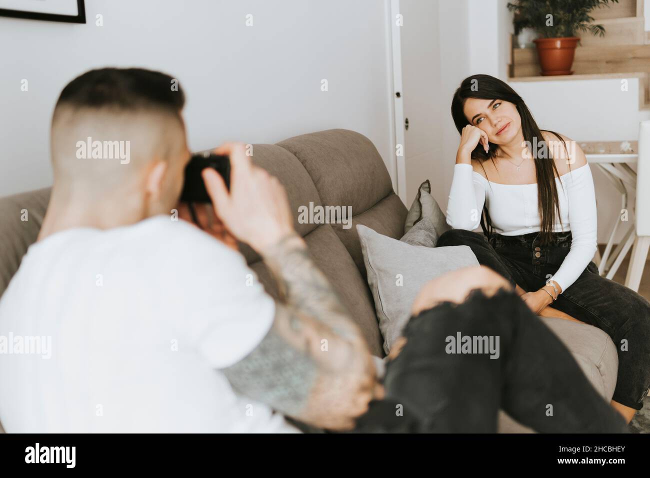 Man photographing woman through camera at home Stock Photo - Alamy