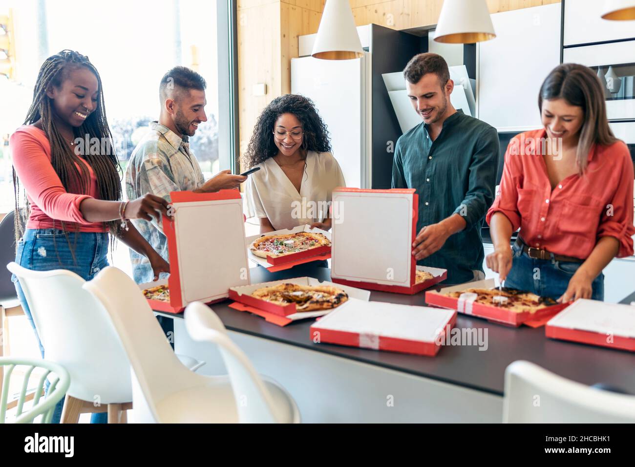 Happy Multiracial Colleagues Eating Pizza At Office Cafeteria Stock