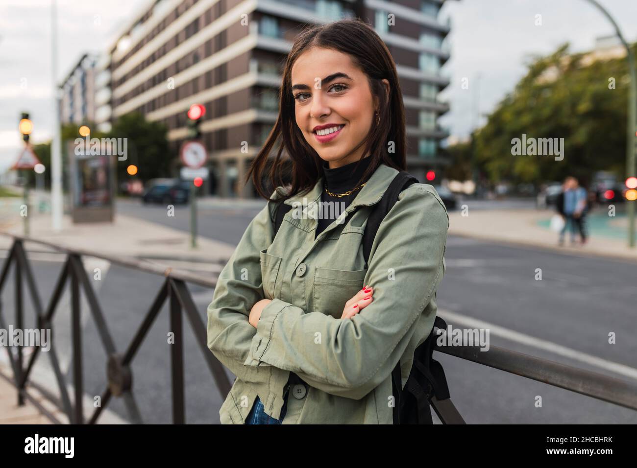Woman with arms crossed leaning on railing Stock Photo - Alamy