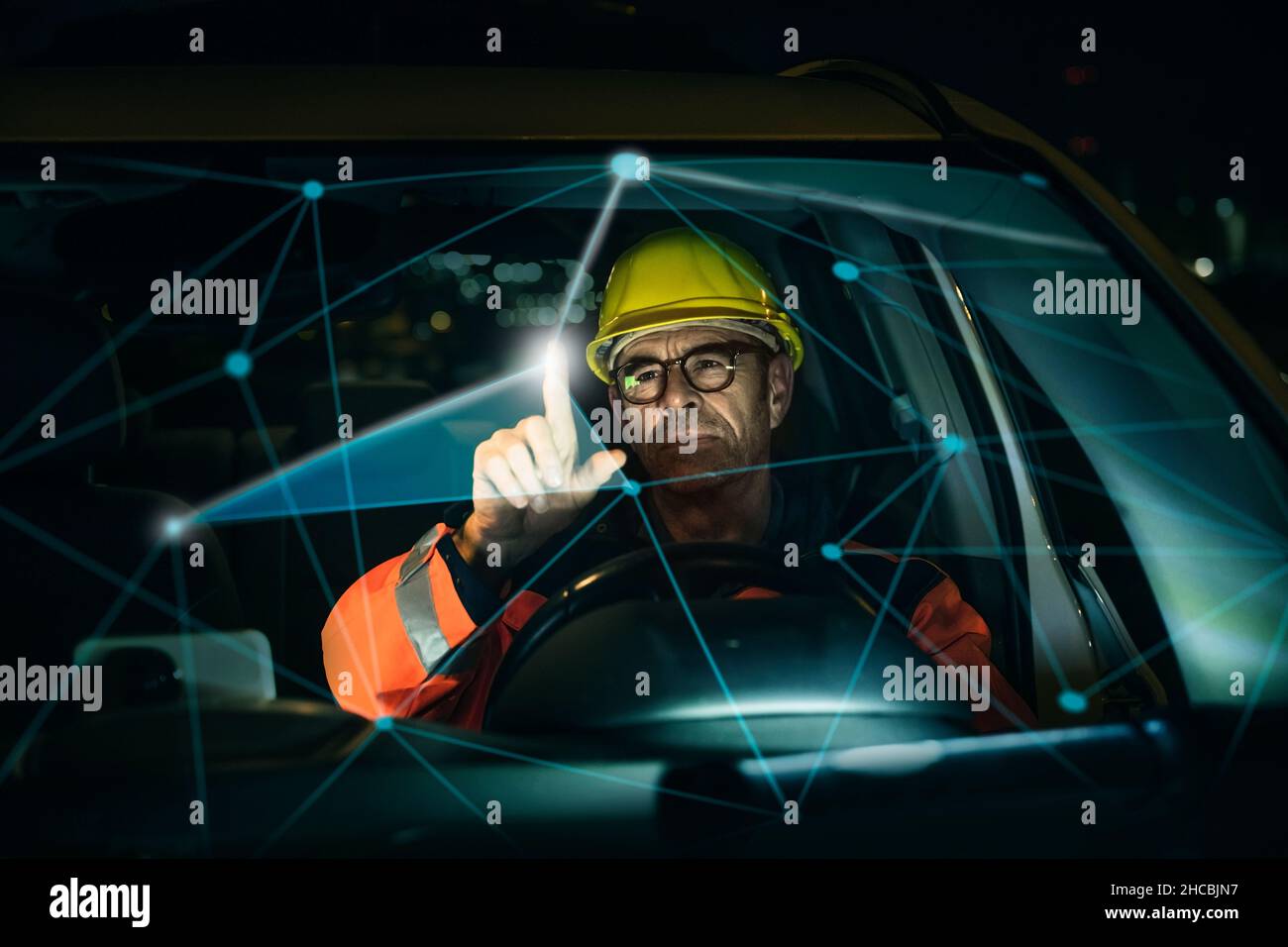 Engineer wearing hardhat working on augmented graph seen through car ...