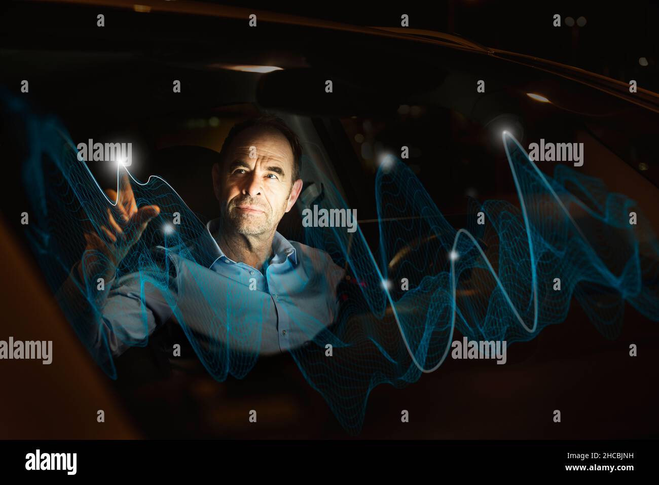 Businessman touching wave graph in car Stock Photo - Alamy