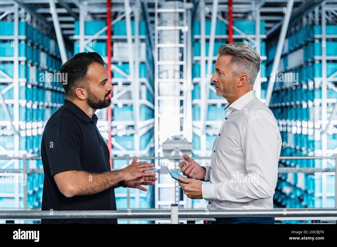 Businessman having discussion with manager at warehouse Stock Photo - Alamy