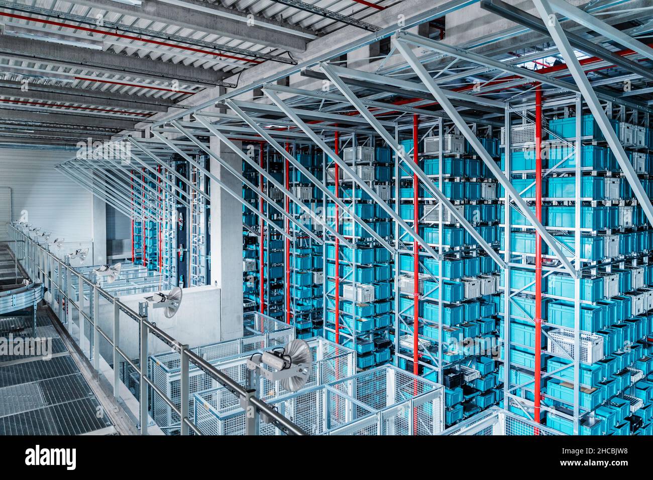 Blue containers in tall racks at warehouse Stock Photo - Alamy