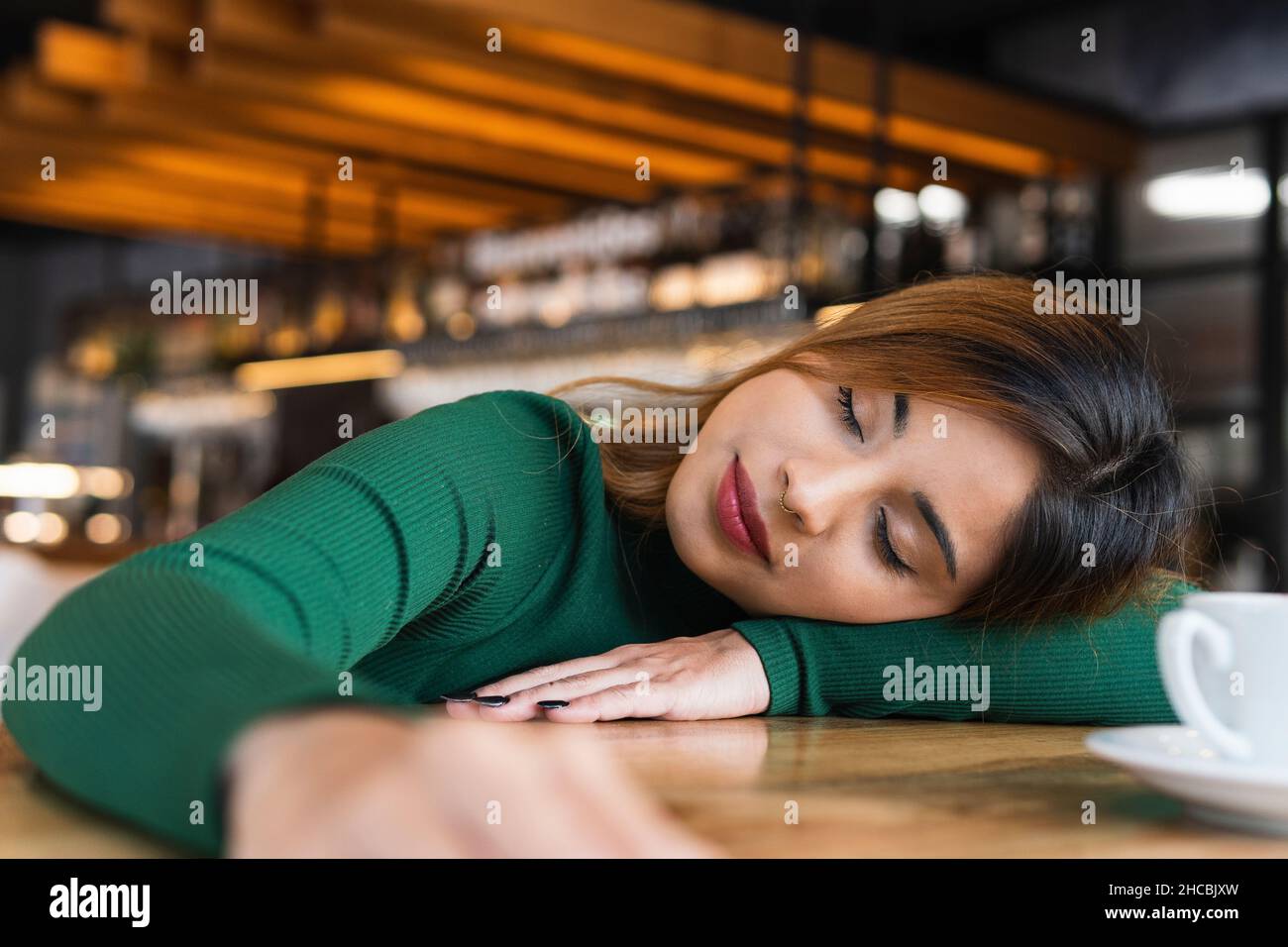 Tired woman relaxing on table in coffee shop Stock Photo - Alamy