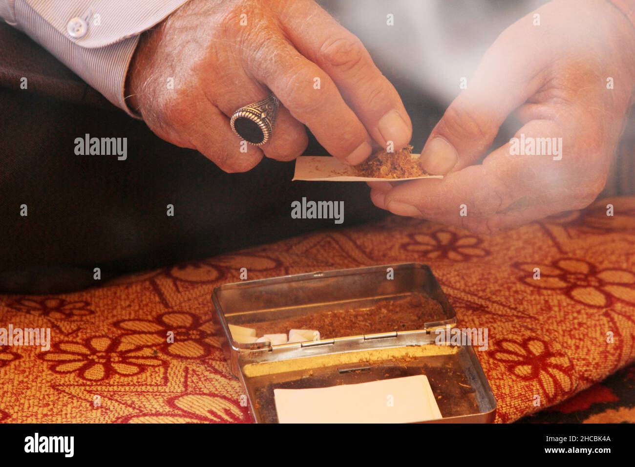 Hands of a man rolling tobacco. Addiction Stock Photo - Alamy