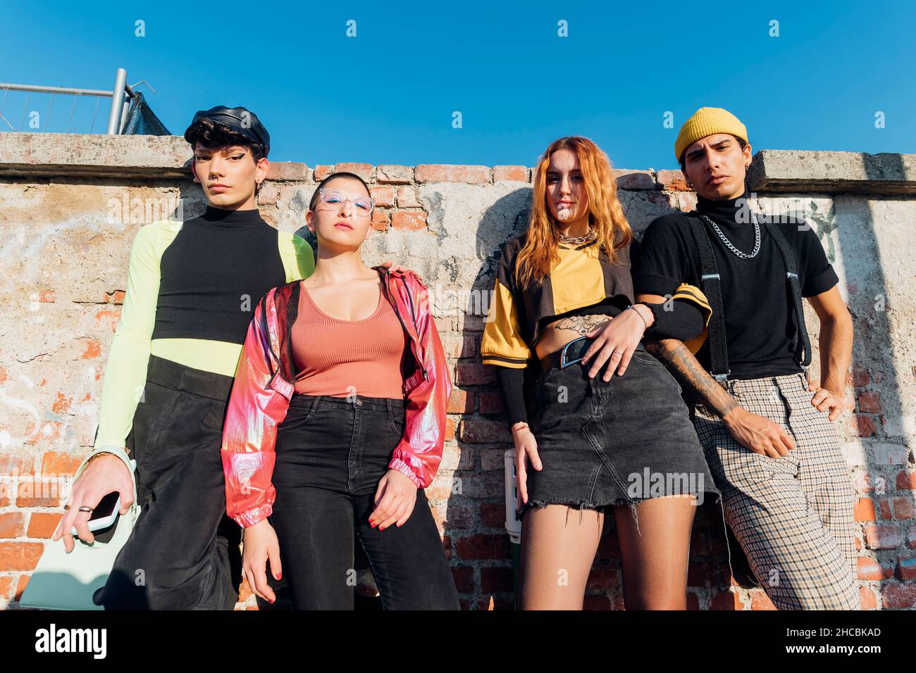 Four friends standing front brick wall hi-res stock photography and ...