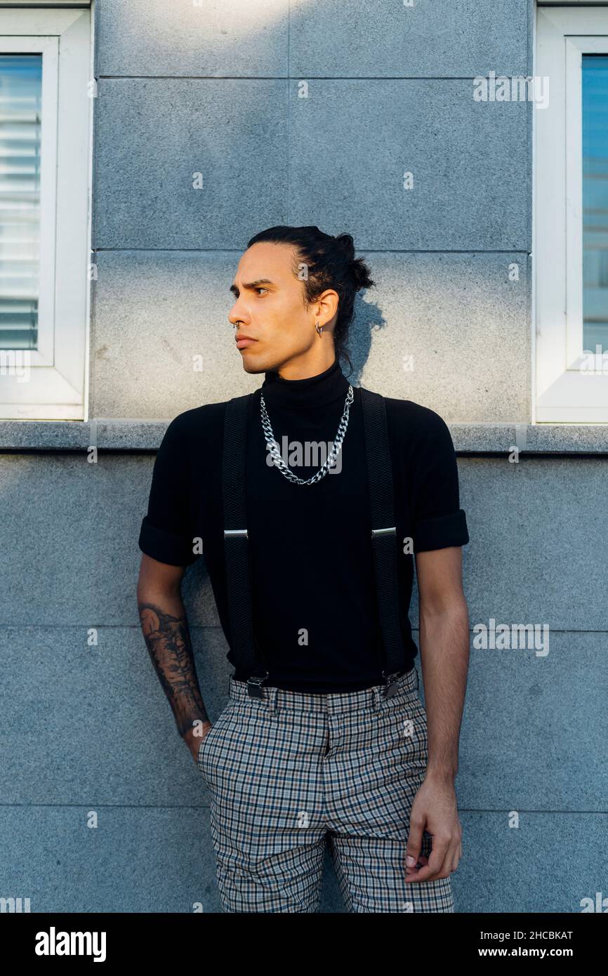 Sunlight on young man standing in front of wall Stock Photo - Alamy