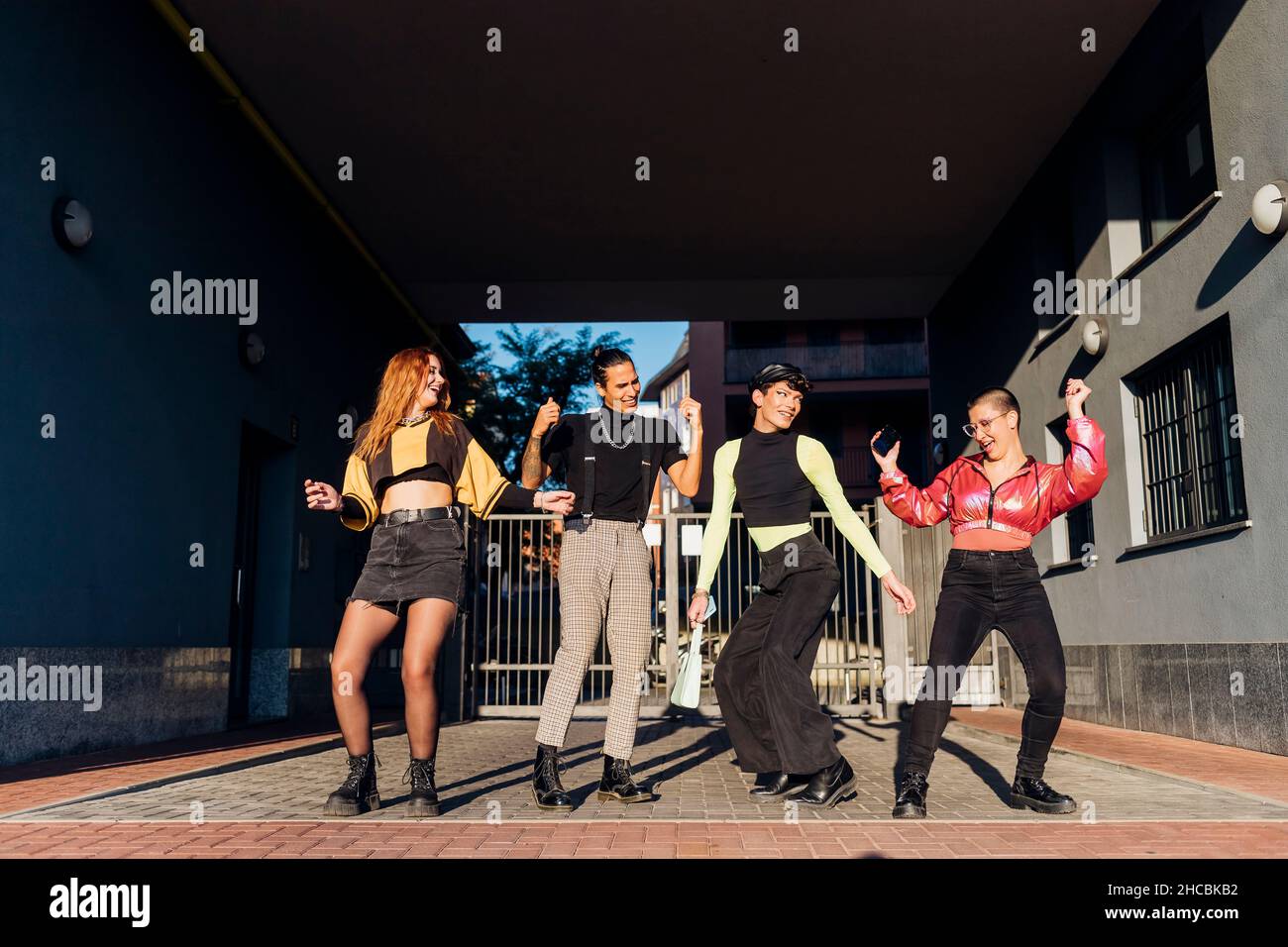 Playful friends dancing together on footpath Stock Photo - Alamy