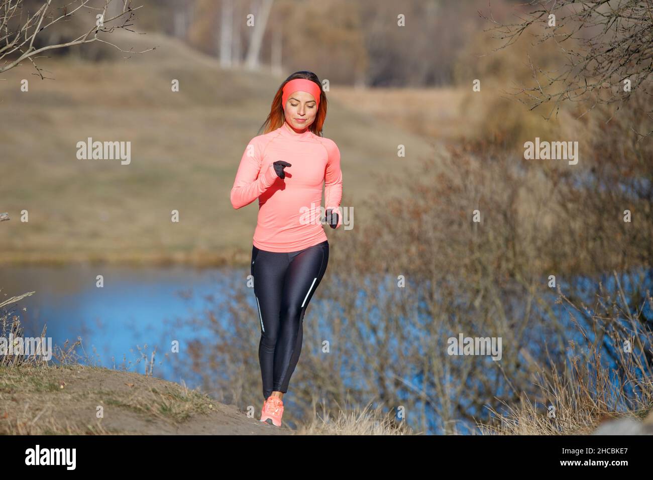 Young fitness woman running in the morning in cold sunny weather Stock ...
