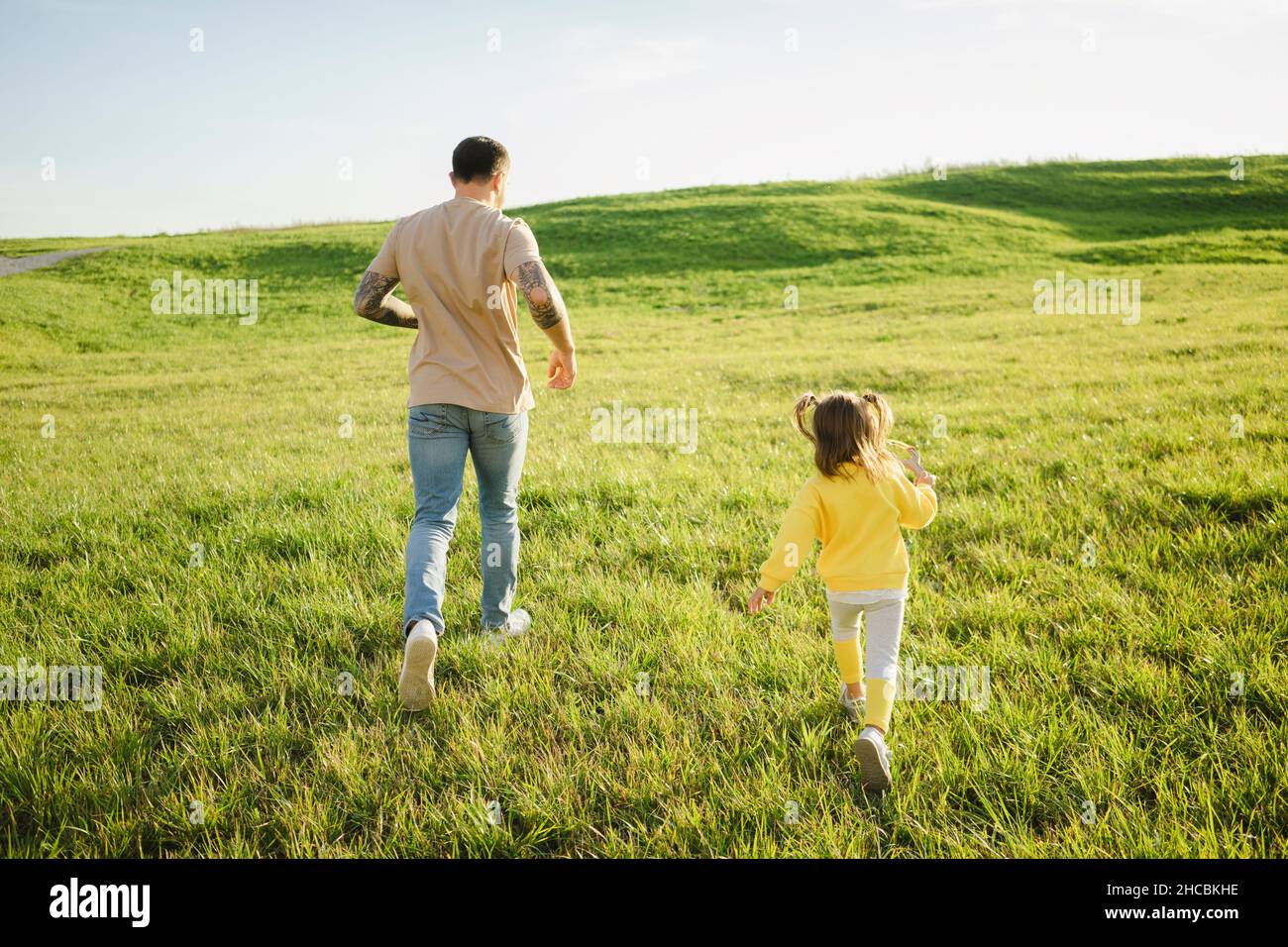 Father and daughter running on meadow landscape Stock Photo - Alamy