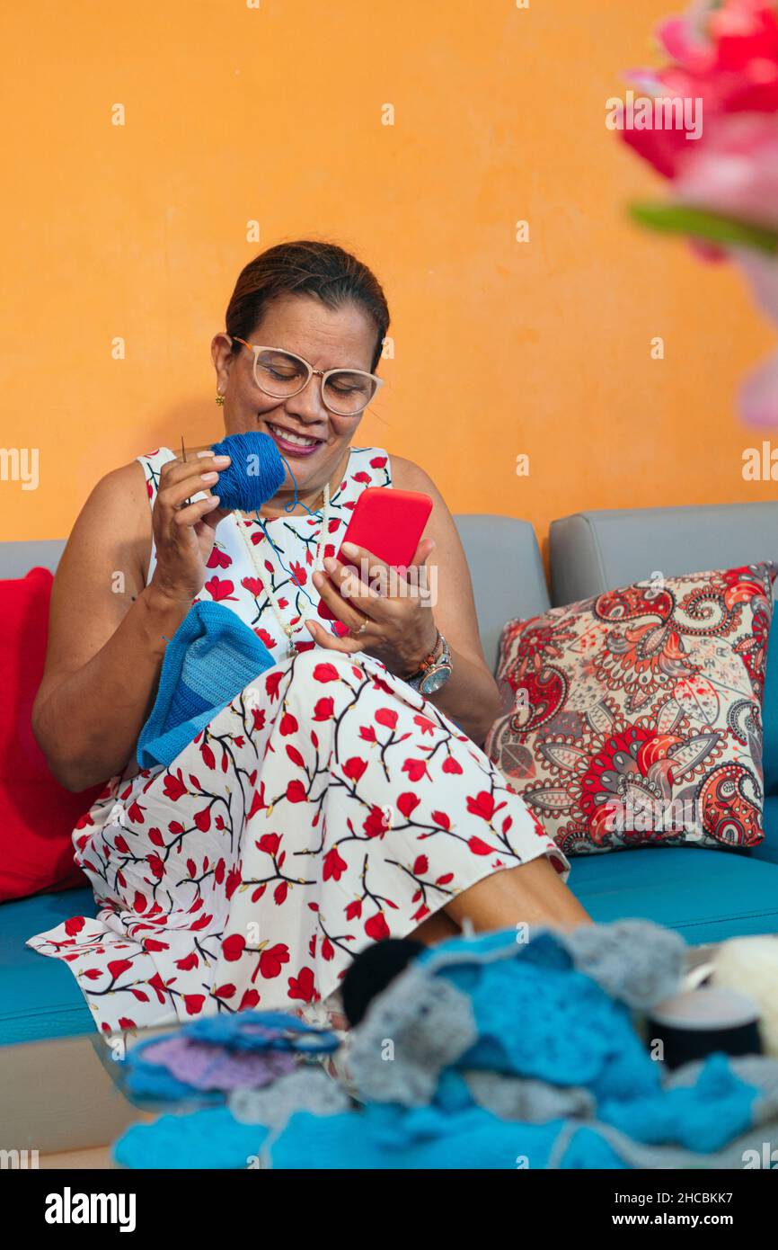 Clothing designer on video phone call while relaxing at home Stock ...
