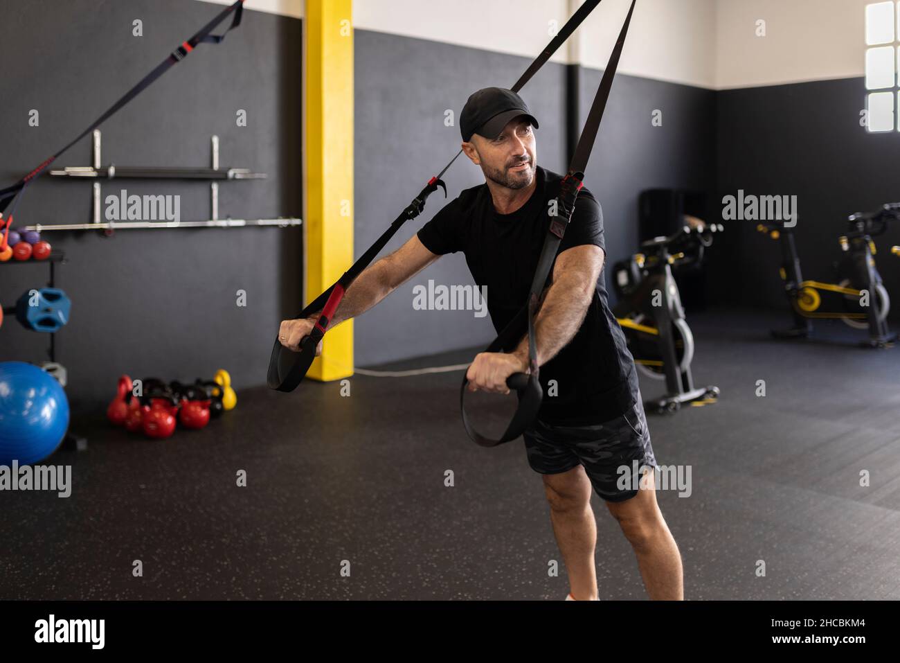 Coach with straps instructing athletes in gym Stock Photo - Alamy