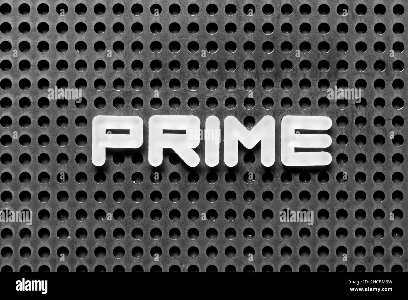 White alphabet letter in word prime on black pegboard background Stock ...