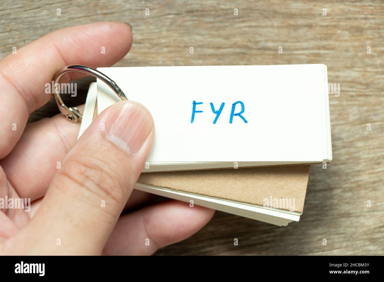 Man hold the flash card with handwriting word FYR (abbreviation of for ...