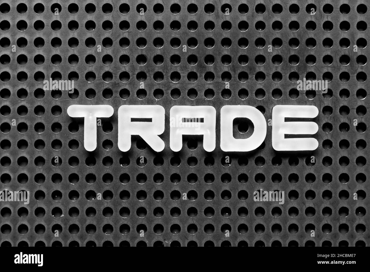 White alphabet letter in word trade on black pegboard background Stock ...