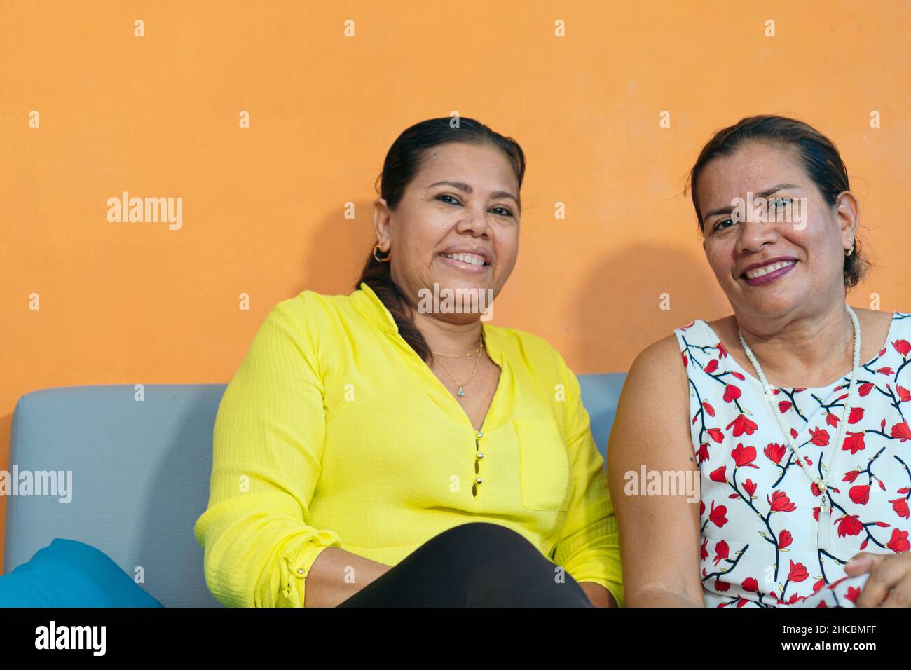 Two mature sisters sitting together on the sofa at home Stock Photo - Alamy