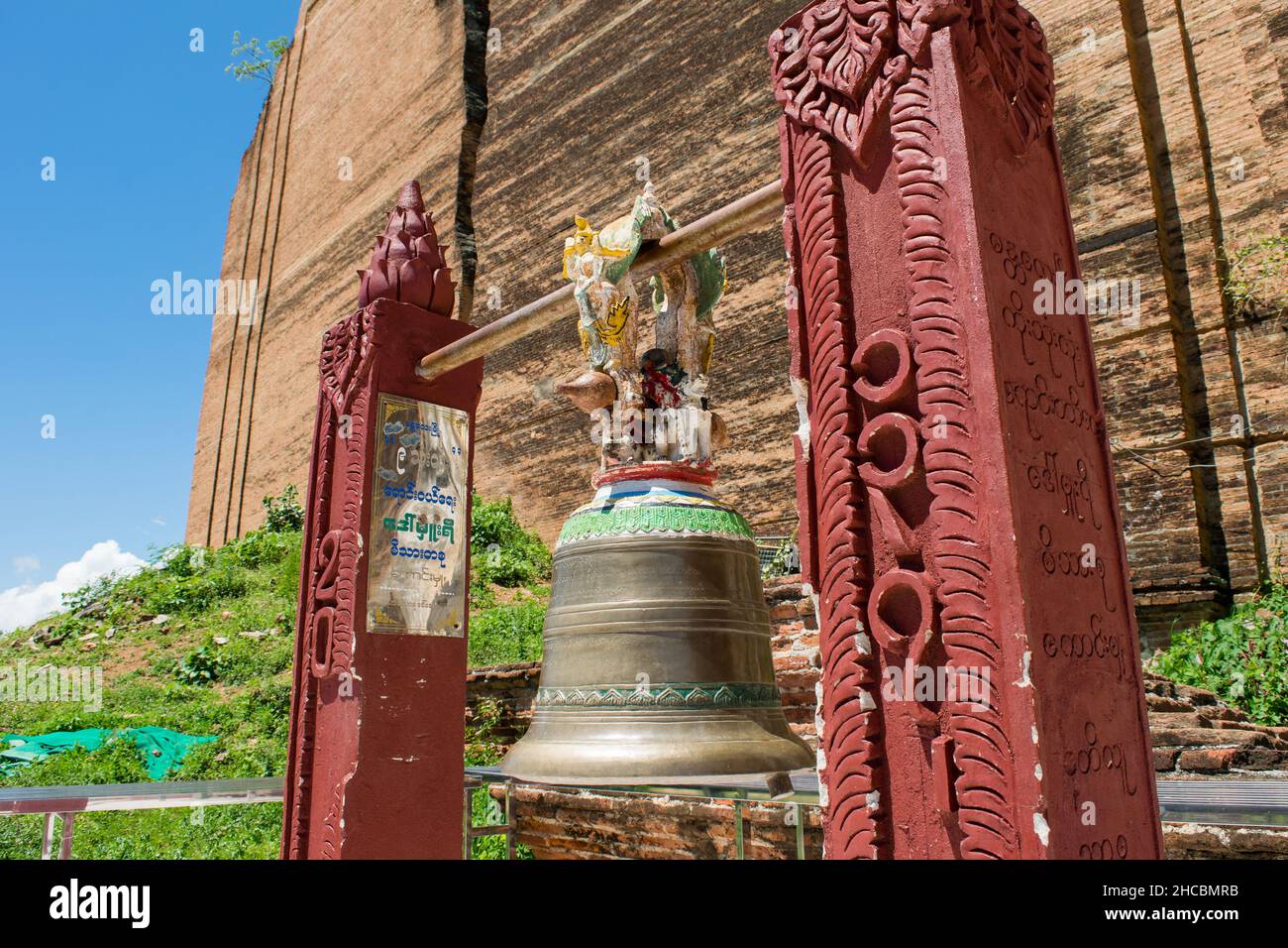 A small bell hanging on to an iron bar supported by two columns, next ...