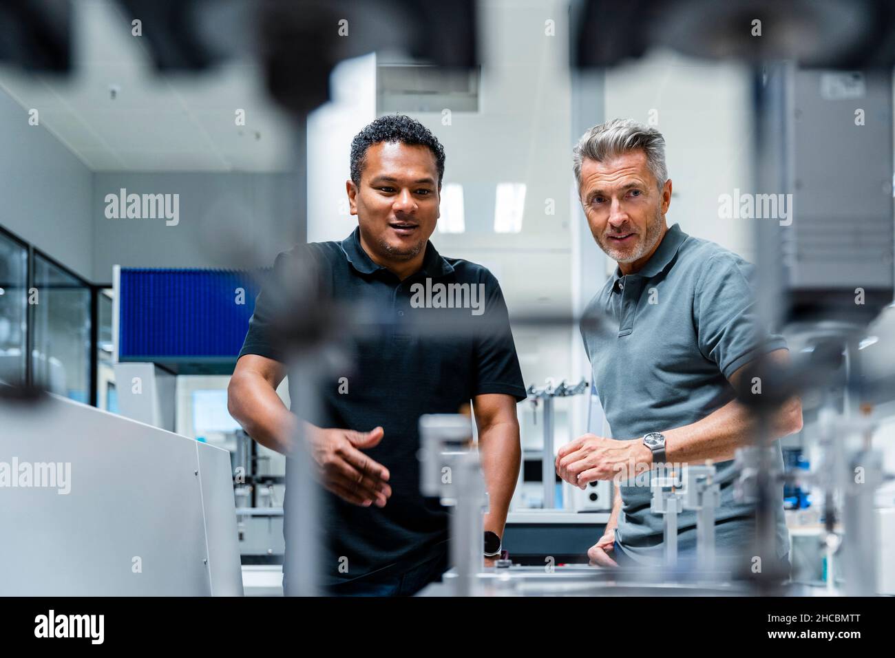 Engineers examining machinery at industry Stock Photo - Alamy