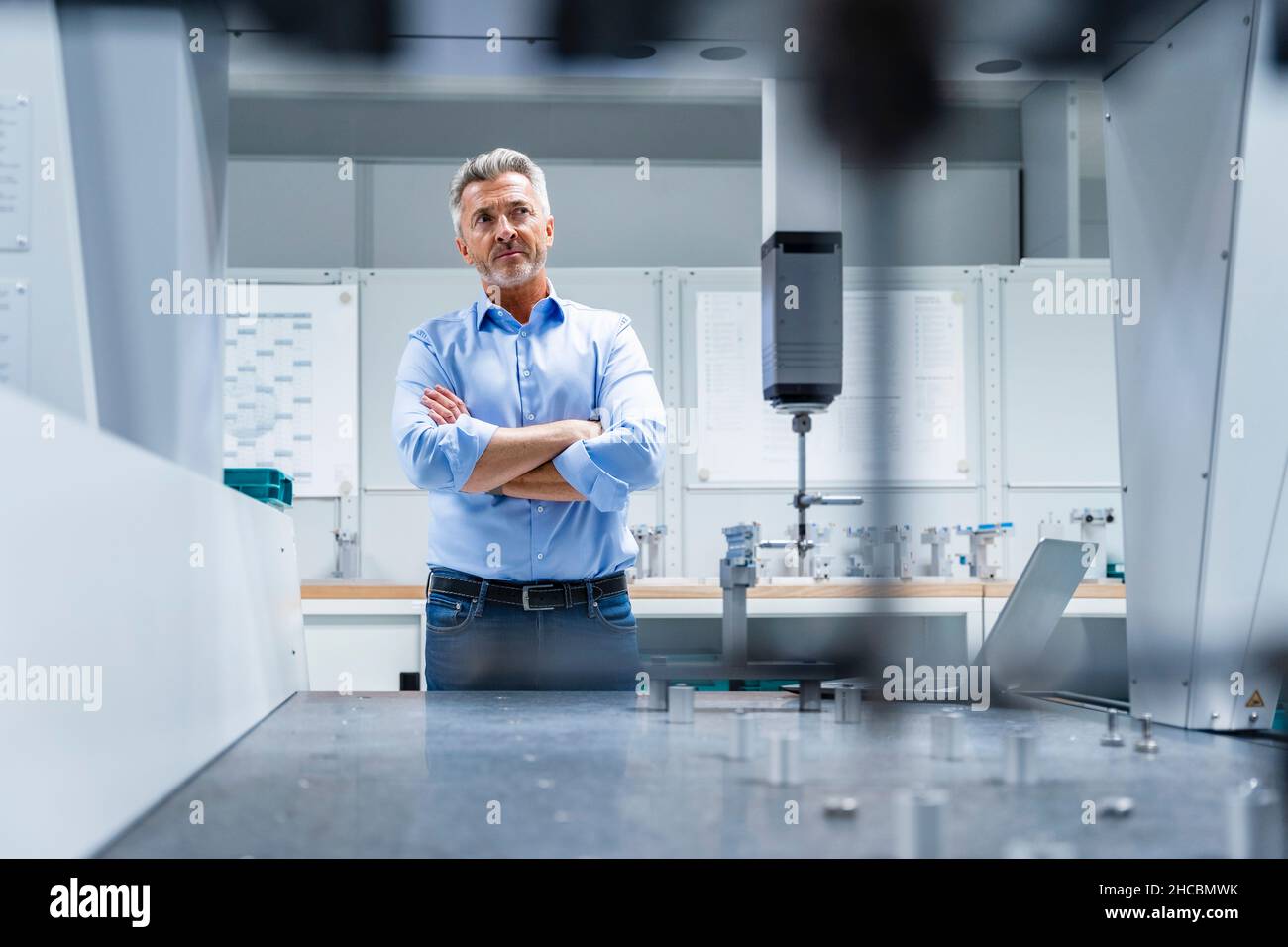 Thoughtful engineer with arms crossed at factory Stock Photo - Alamy