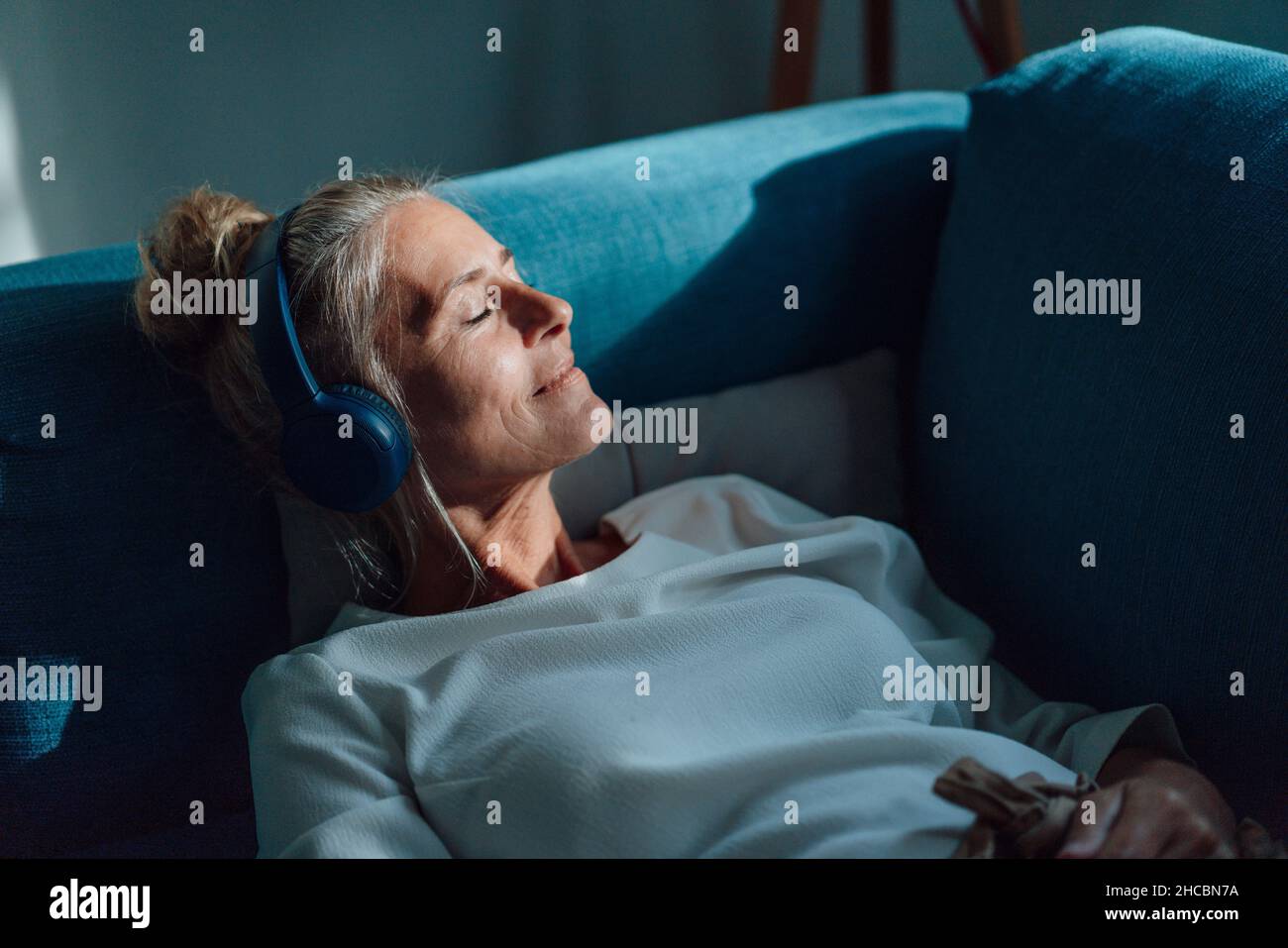 Woman relaxing with feet up on sofa at home Stock Photo - Alamy