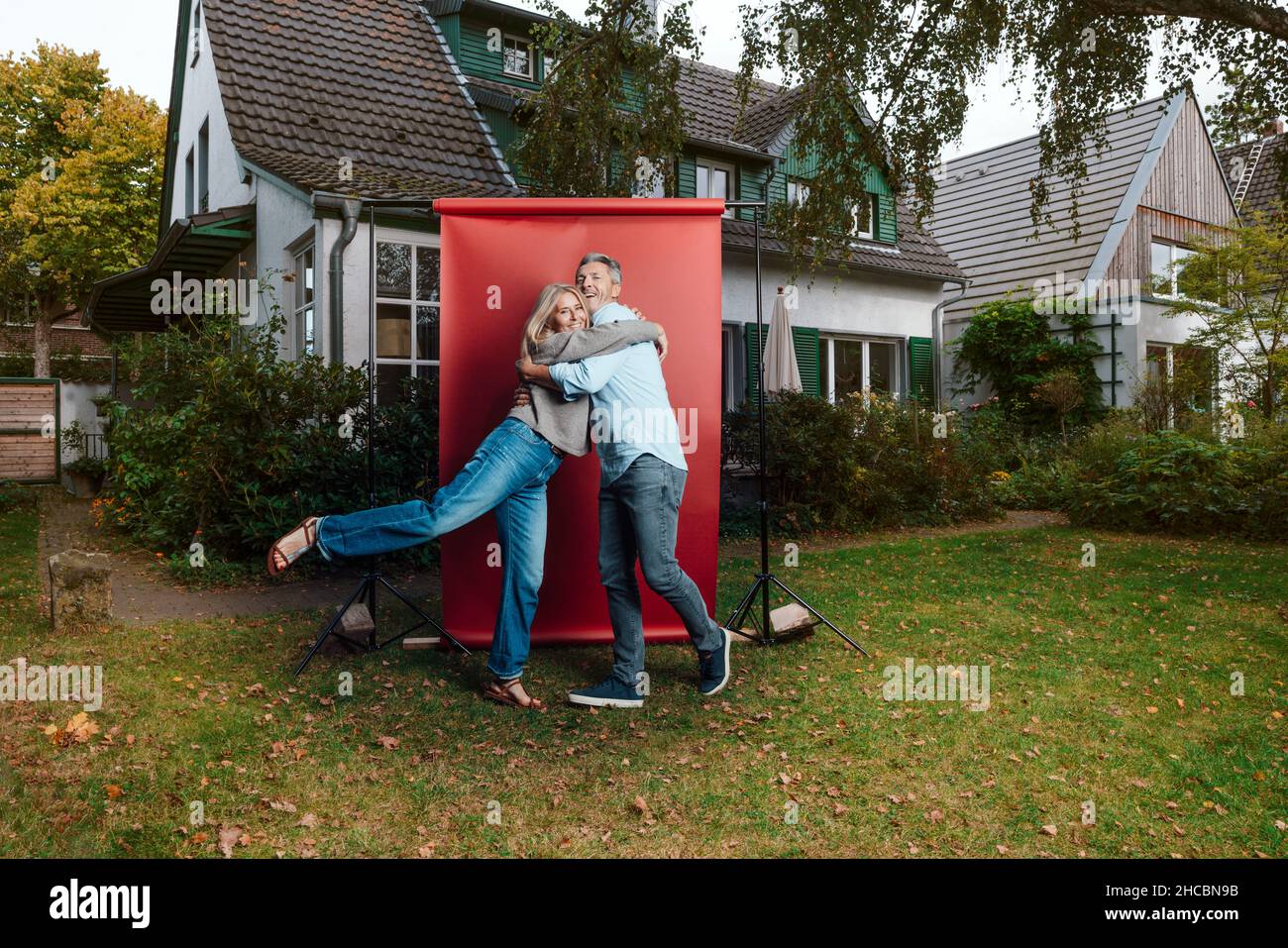 Smiling man sitting on stool at backyard Stock Photo - Alamy
