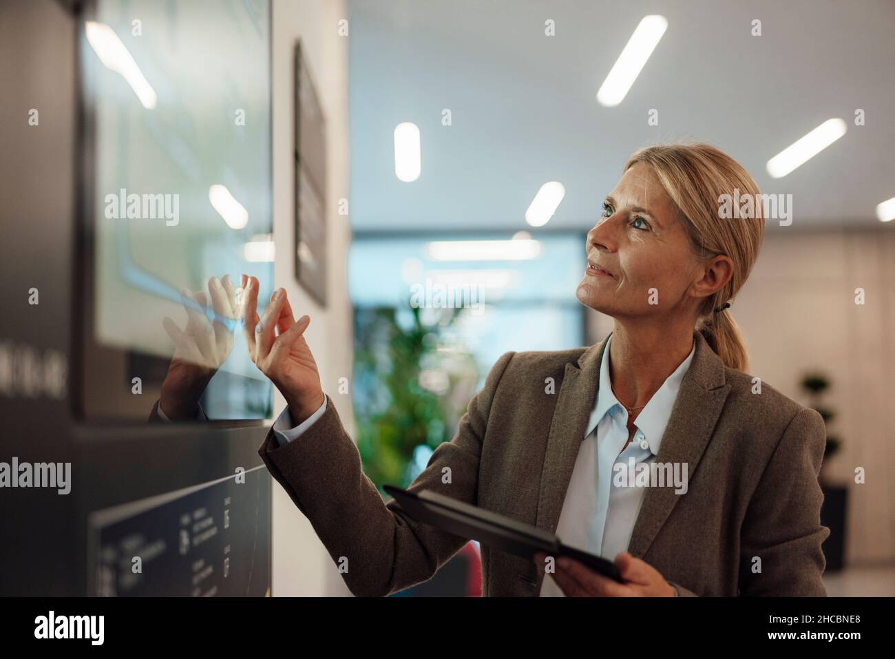 Reflection of businesswoman with arms crossed on glass wall Stock Photo ...