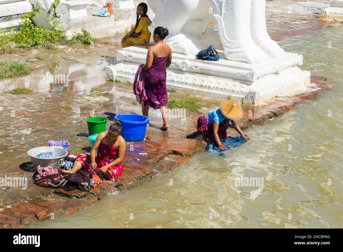 People bathing and washing on the riverbank of Irrawaddy River, next to ...