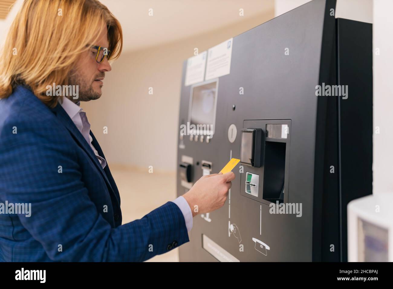 Businessman using credit card at ATM machine Stock Photo - Alamy