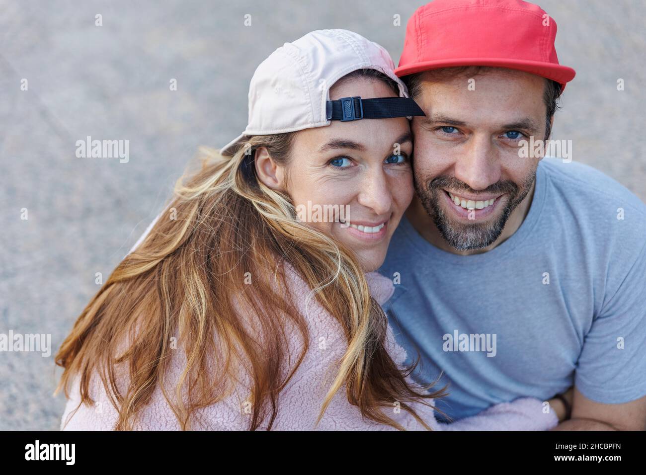Happy couple wearing caps embracing each other Stock Photo - Alamy