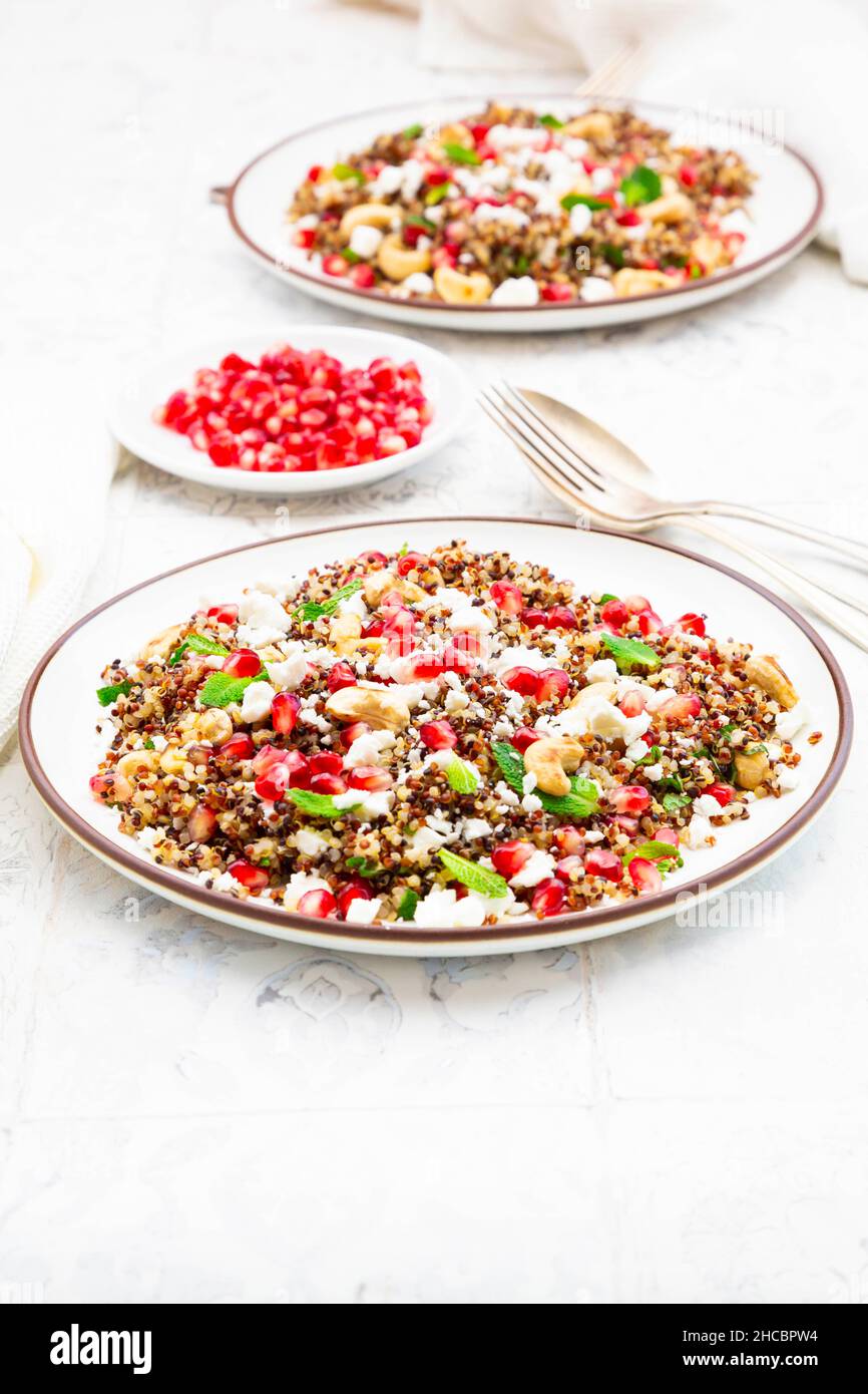 Studio shot of two plates of quinoa salad with feta cheese, pomegranate ...