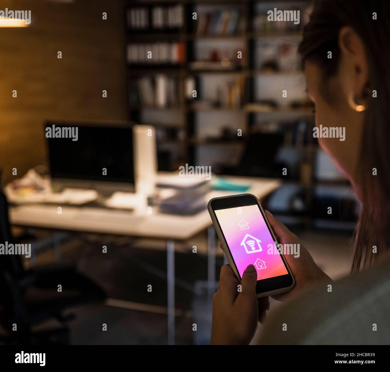 Woman controlling smart home device through mobile phone Stock Photo ...