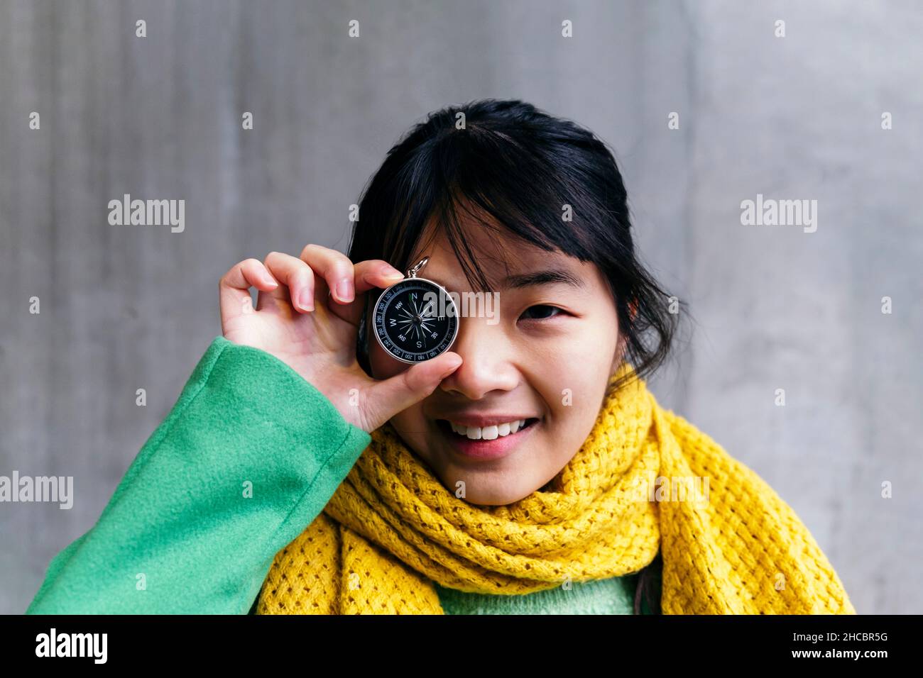 Happy woman with navigational compass in front of eye Stock Photo - Alamy