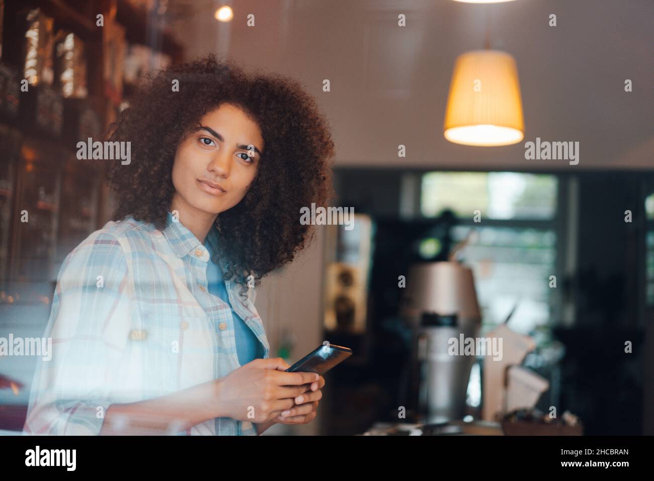 Coffee roaster with smart phone in roastery Stock Photo - Alamy