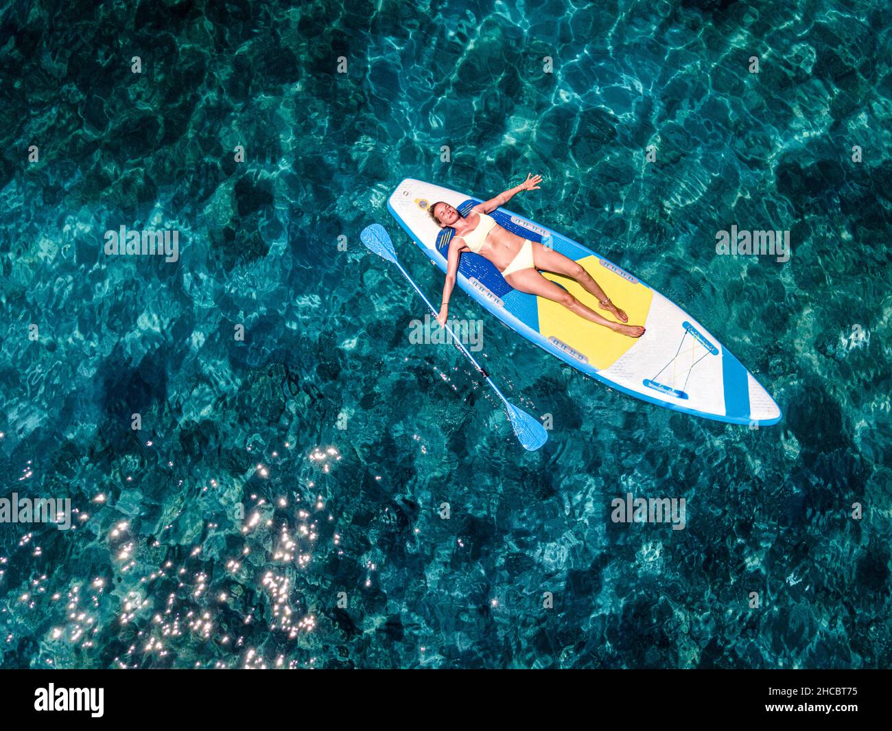 Woman lying on paddleboard in sea during vacation Stock Photo - Alamy