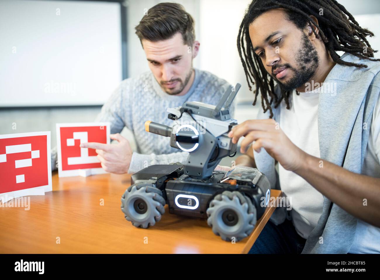 Engineers analyzing robotic combat tank at workshop Stock Photo - Alamy