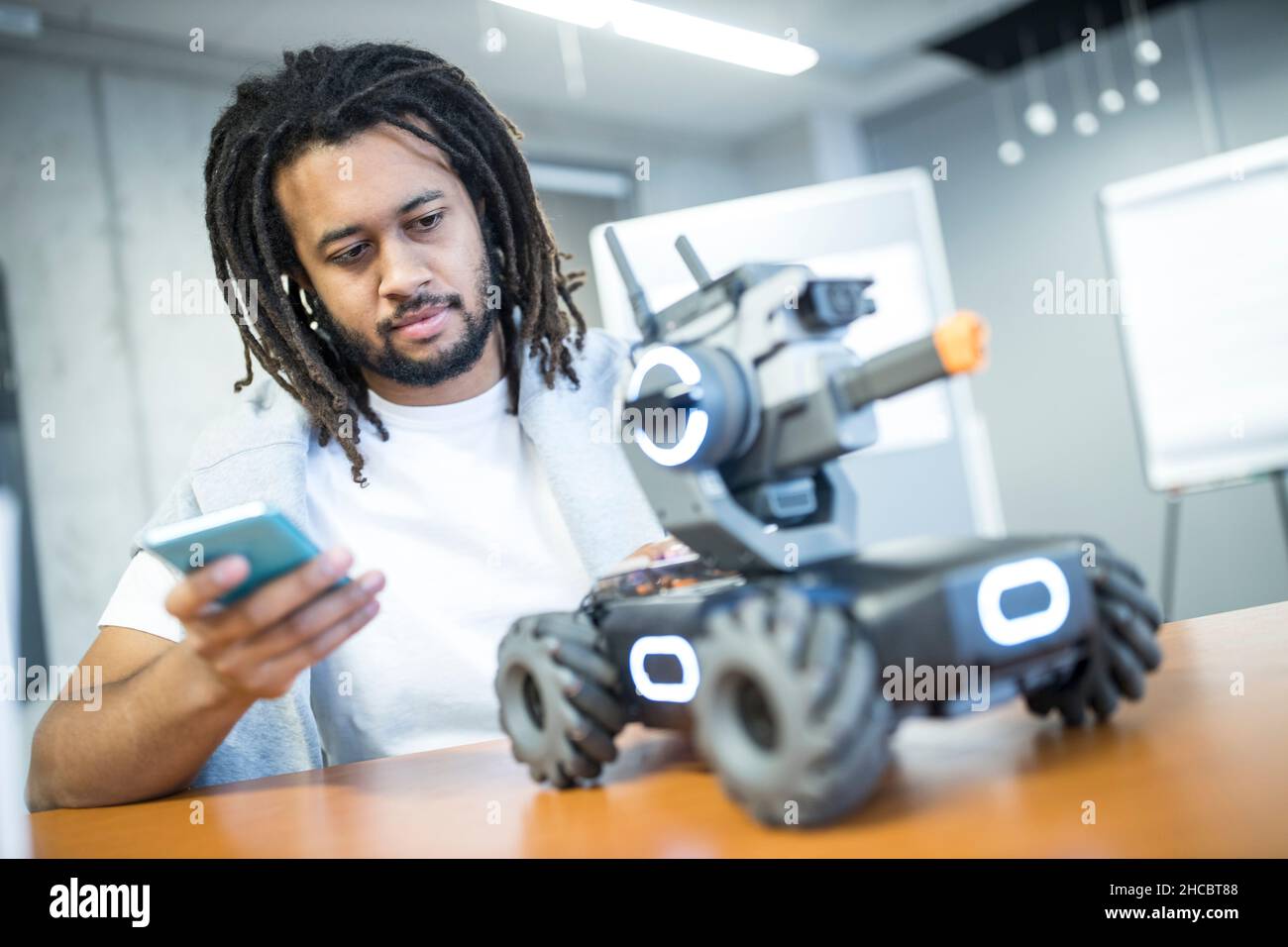 Technician examining robotic combat tank holding remote control at ...