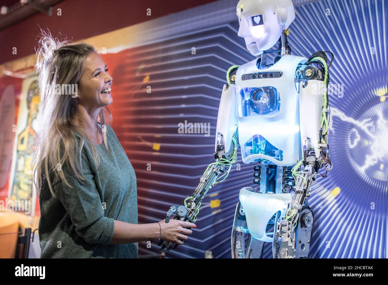 Happy technician shaking hands with human robot at workshop Stock Photo ...
