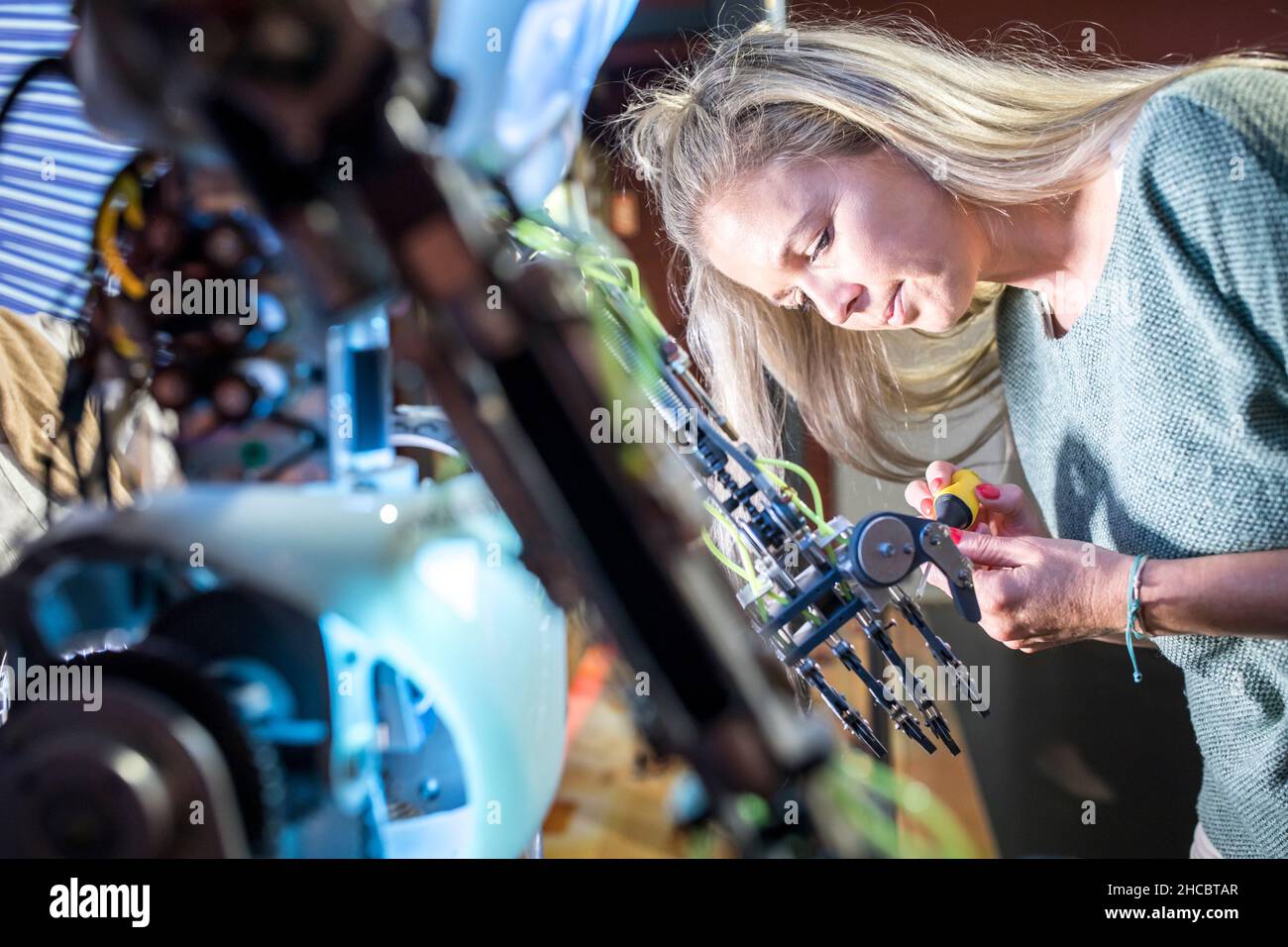 Engineer fixing robotic arm with screwdriver at workshop Stock Photo ...