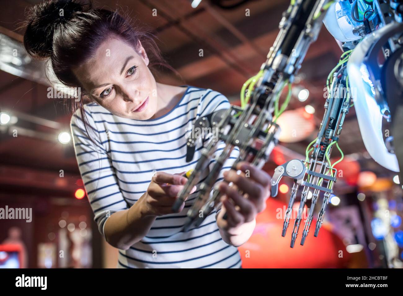 Engineer repairing robotic arm in workshop Stock Photo - Alamy