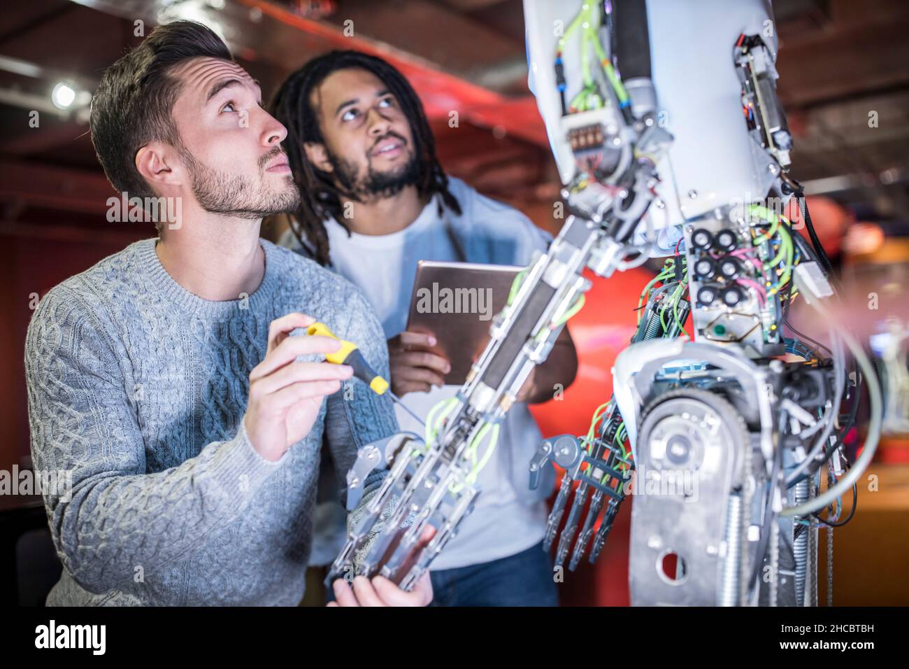 Engineers examining robotic arm at workshop Stock Photo - Alamy