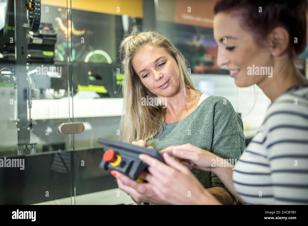 Technicians operating robots through device at workshop Stock Photo - Alamy