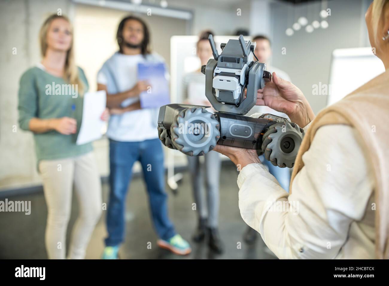 Developer introducing robotic combat tank model to team at workshop ...