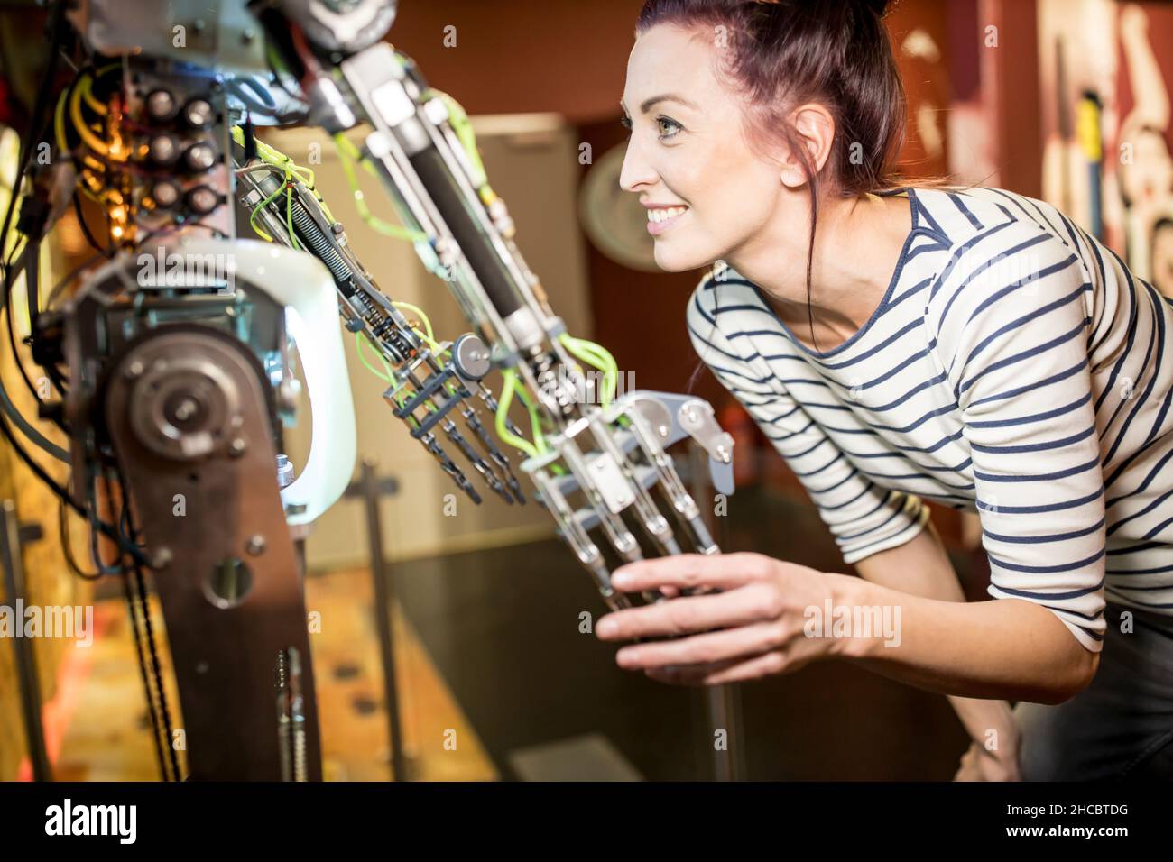 Smiling technician shaking hand with human robot at workshop Stock ...