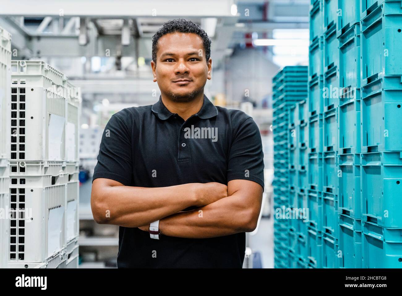 Inspector with arms crossed at crates warehouse Stock Photo - Alamy