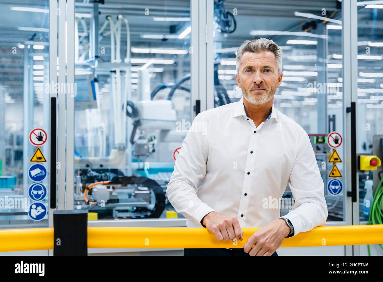 Businessman standing at automated factory Stock Photo - Alamy