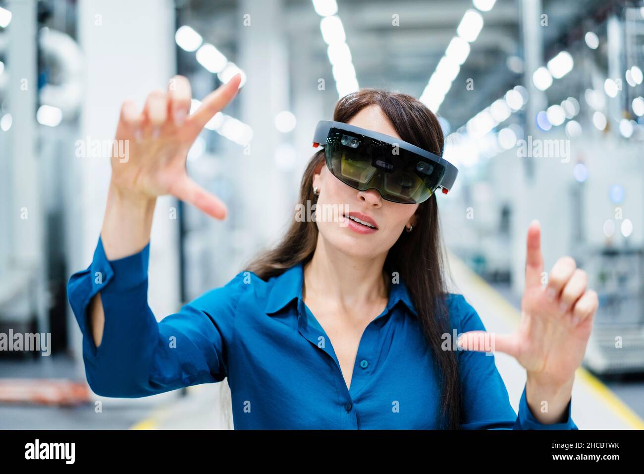 Businesswoman using augmented reality eyeglasses at industry Stock ...